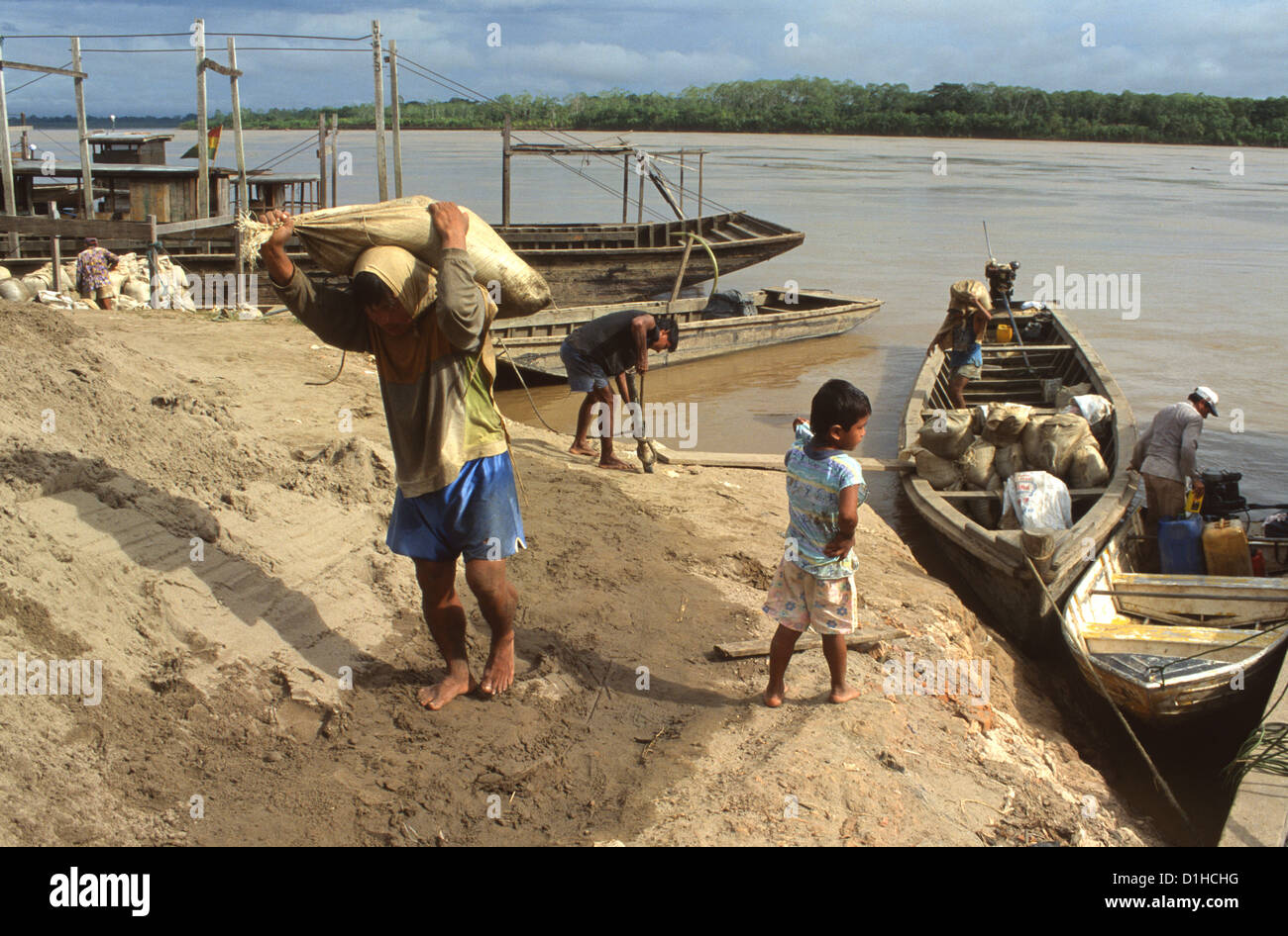 Native indigenous man unloading cargo from a boat in the Amazon region ...