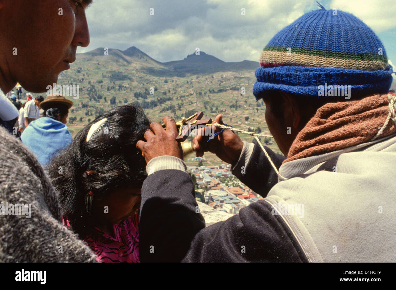 Native Aymara shaman priest blessing people with crucifix on the shores ...