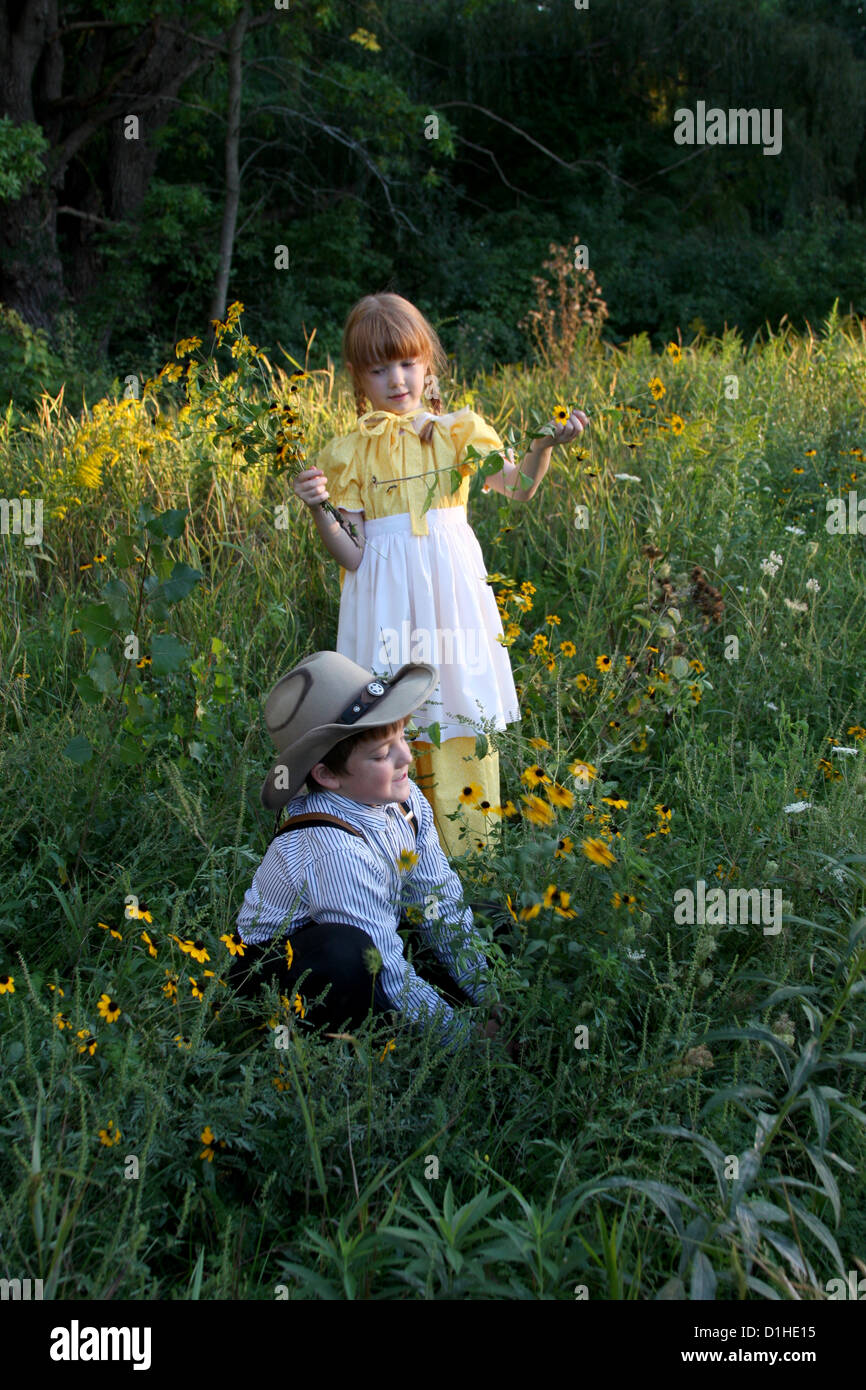 A young boy pulling out flowers to give to a young girl. Focus on the ...