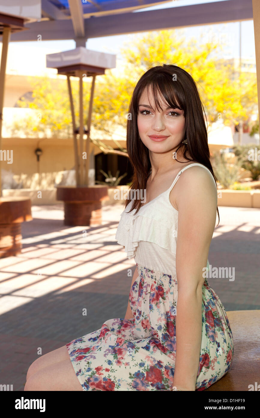 Pretty woman sitting outside Stock Photo - Alamy