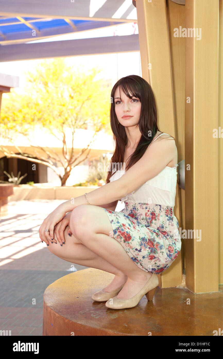 Pretty woman sitting outside Stock Photo - Alamy