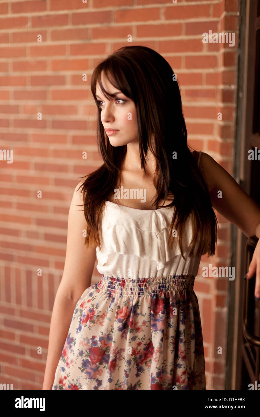 Pretty woman standing in front of a brick wall Stock Photo - Alamy