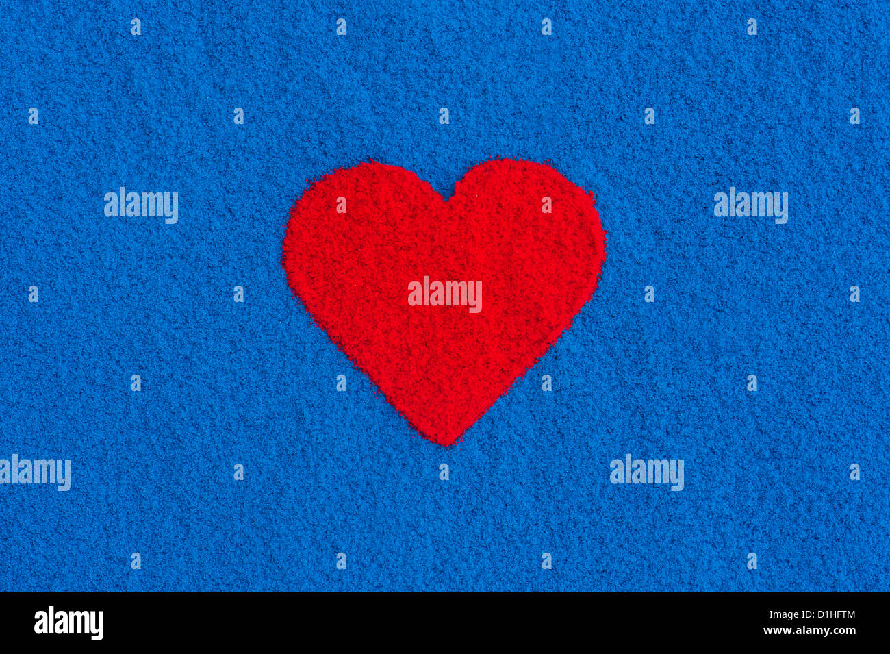 Red heart shape on a blue coloured powder Stock Photo - Alamy