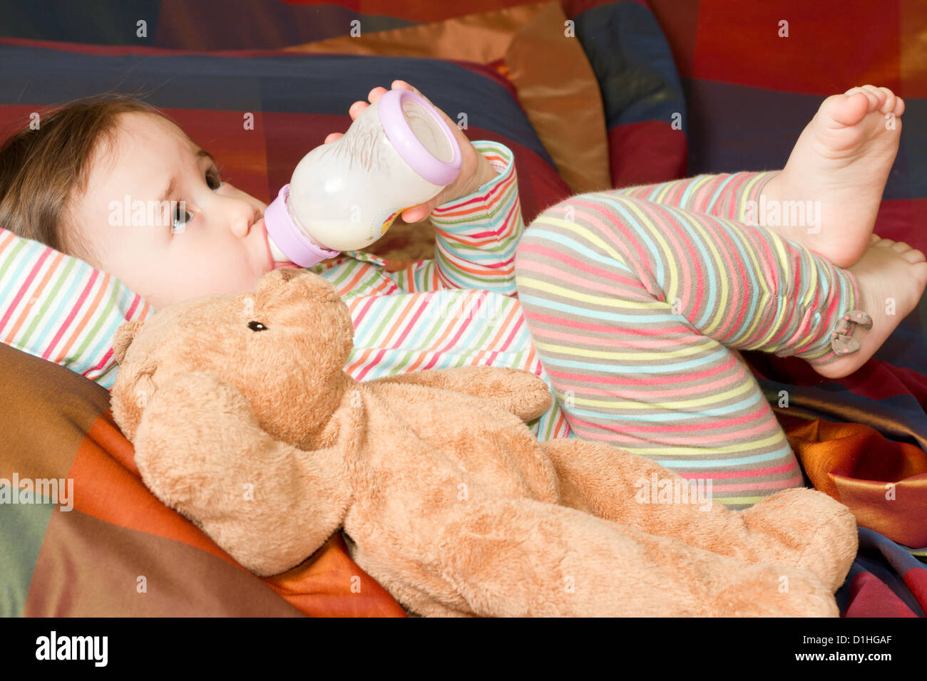 pretty baby girl with infant formula in bottle on bad Stock Photo - Alamy