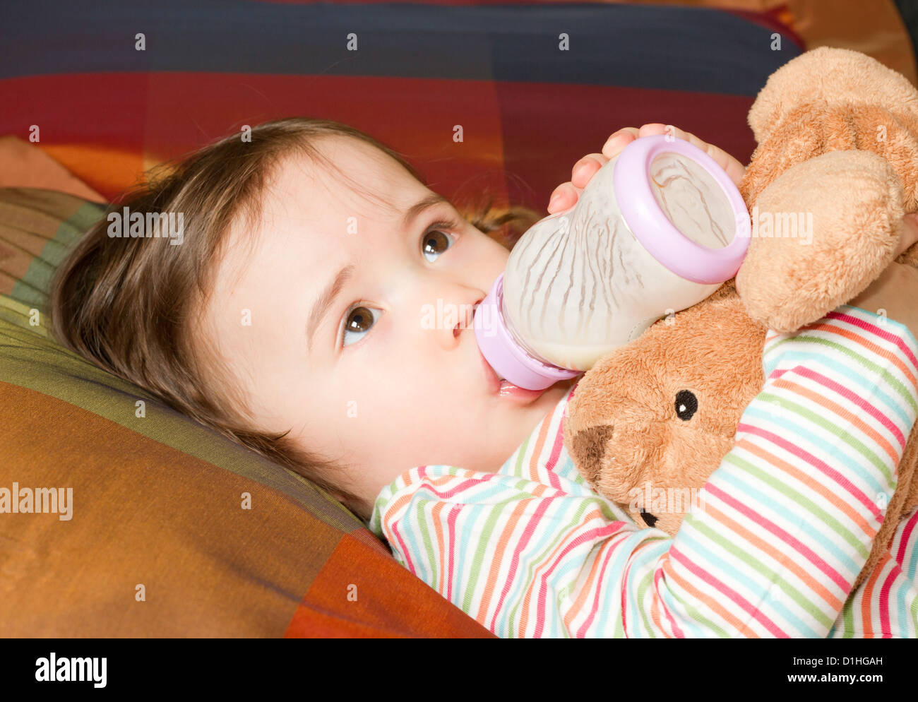 pretty baby girl with infant formula in bottle on bad Stock Photo - Alamy