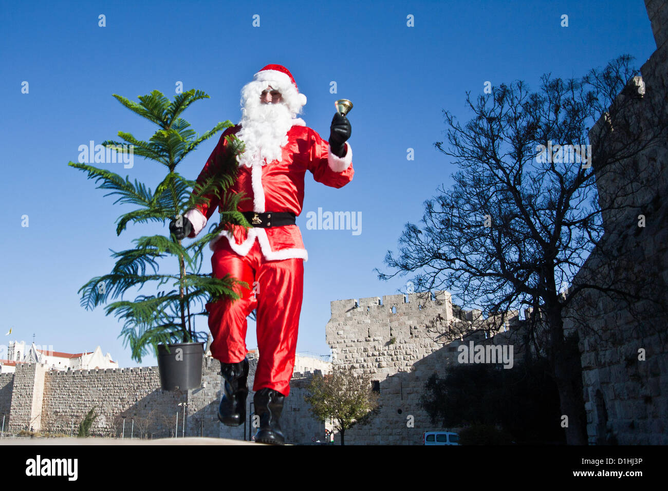 Issa, in a Santa Claus costume, rings his bell and wishes everyone a ...