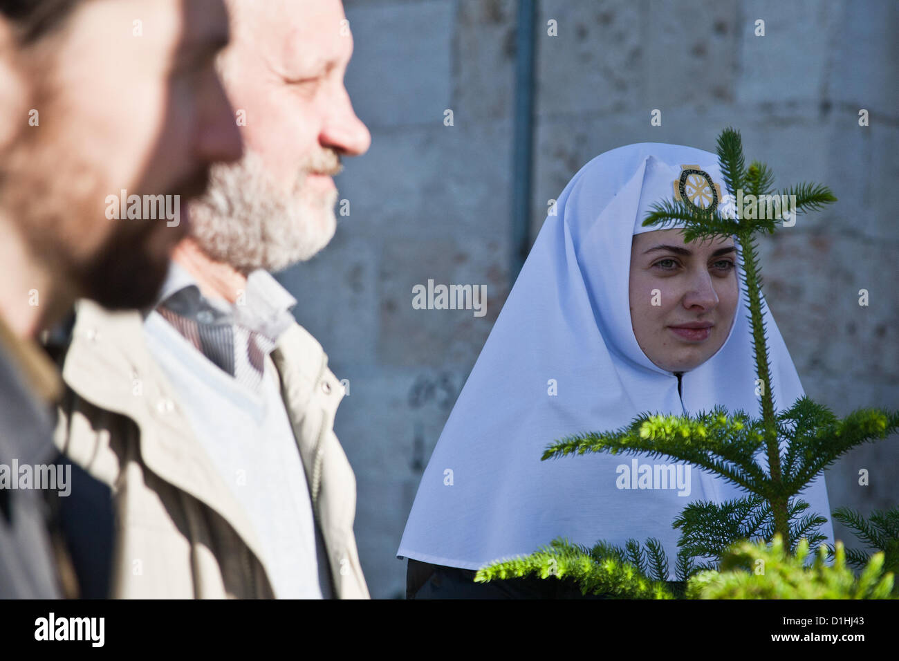 A nun holds a Christmas tree just received at a distribution site at ...