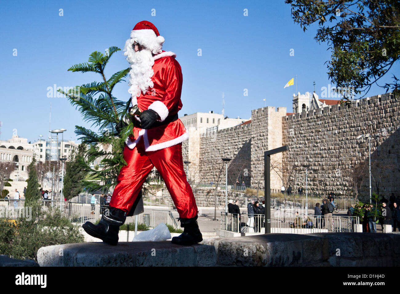 Issa, in a Santa Claus costume, rings his bell and wishes everyone a ...