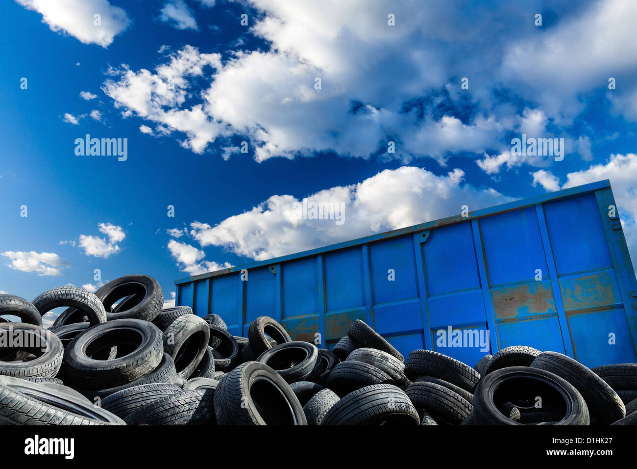 Recycling container with stack of car tires over blue sky. Ecology ...