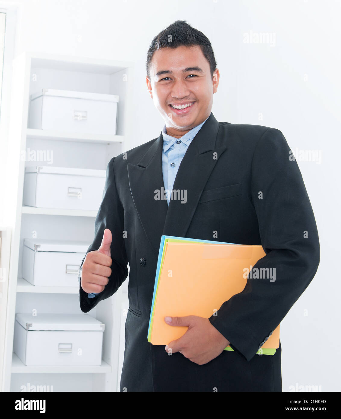 Thumb up Southeast Asian executive standing in office Stock Photo - Alamy