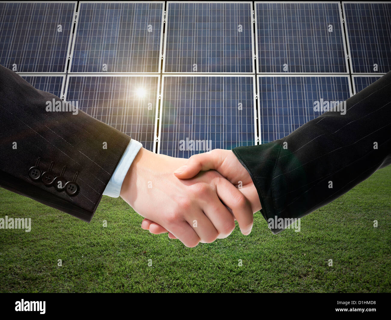 Male and female hand sign deal on background of solar panels and green ...