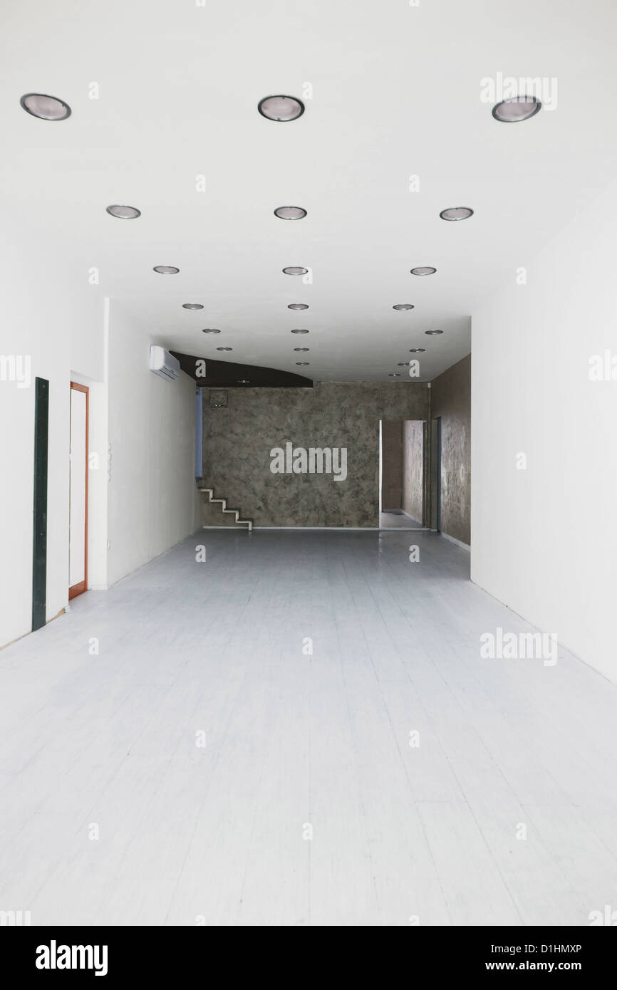 Long white corridor with the door at the end and left Stock Photo - Alamy