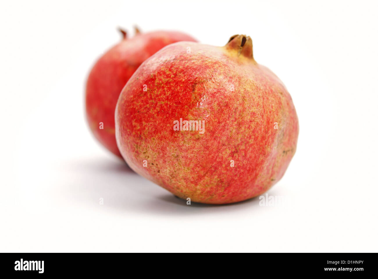 Two red pomegranates on white background Stock Photo - Alamy