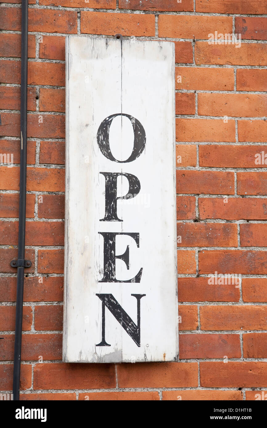 Old White Open Sign on Red Brick Wall Stock Photo - Alamy