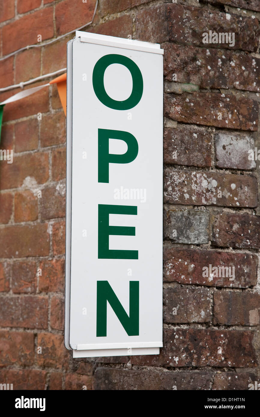 Green Open Sign against Red Brick Wall Stock Photo - Alamy