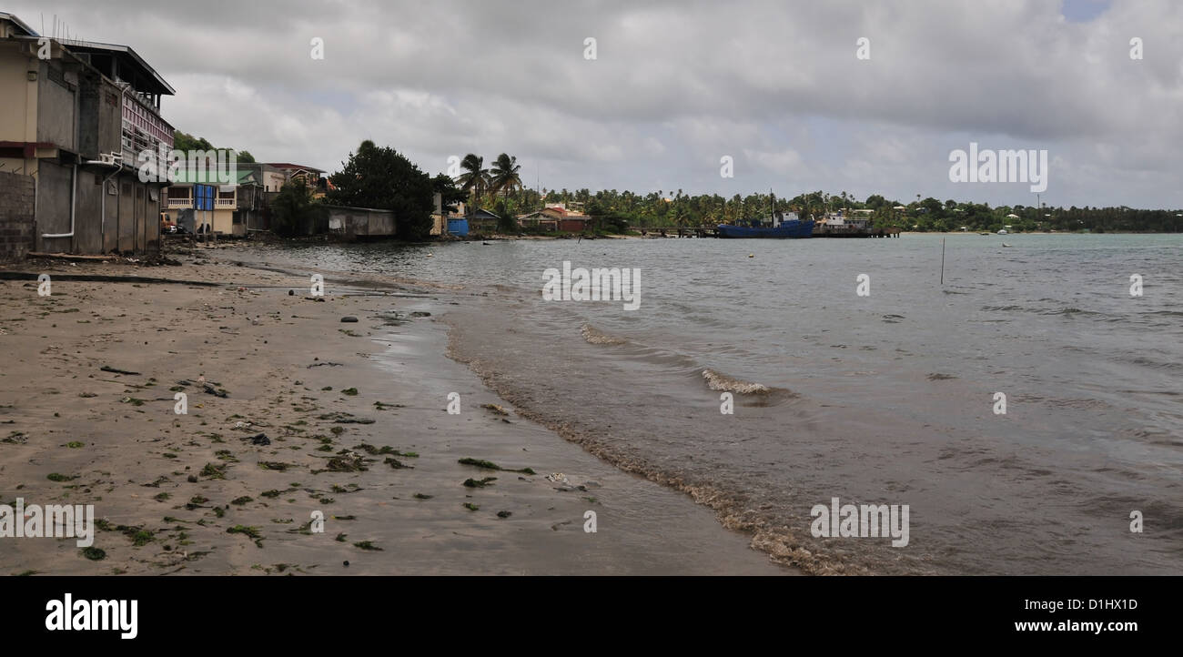 Grey cumulus clouds coastal view wet beach sand, sea, houses, Grenville ...
