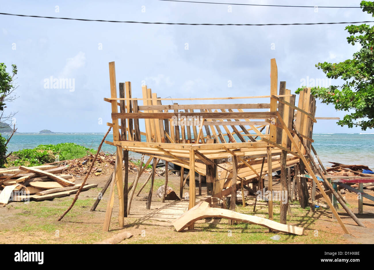 Blue sky white clouds beach view cedar wood boat being built on stocks ...