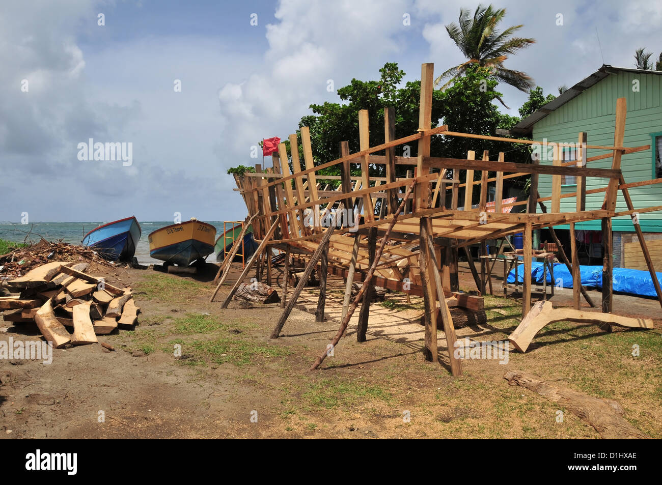 Blue sky white clouds view cedar wood boat being built, 3 small boats ...