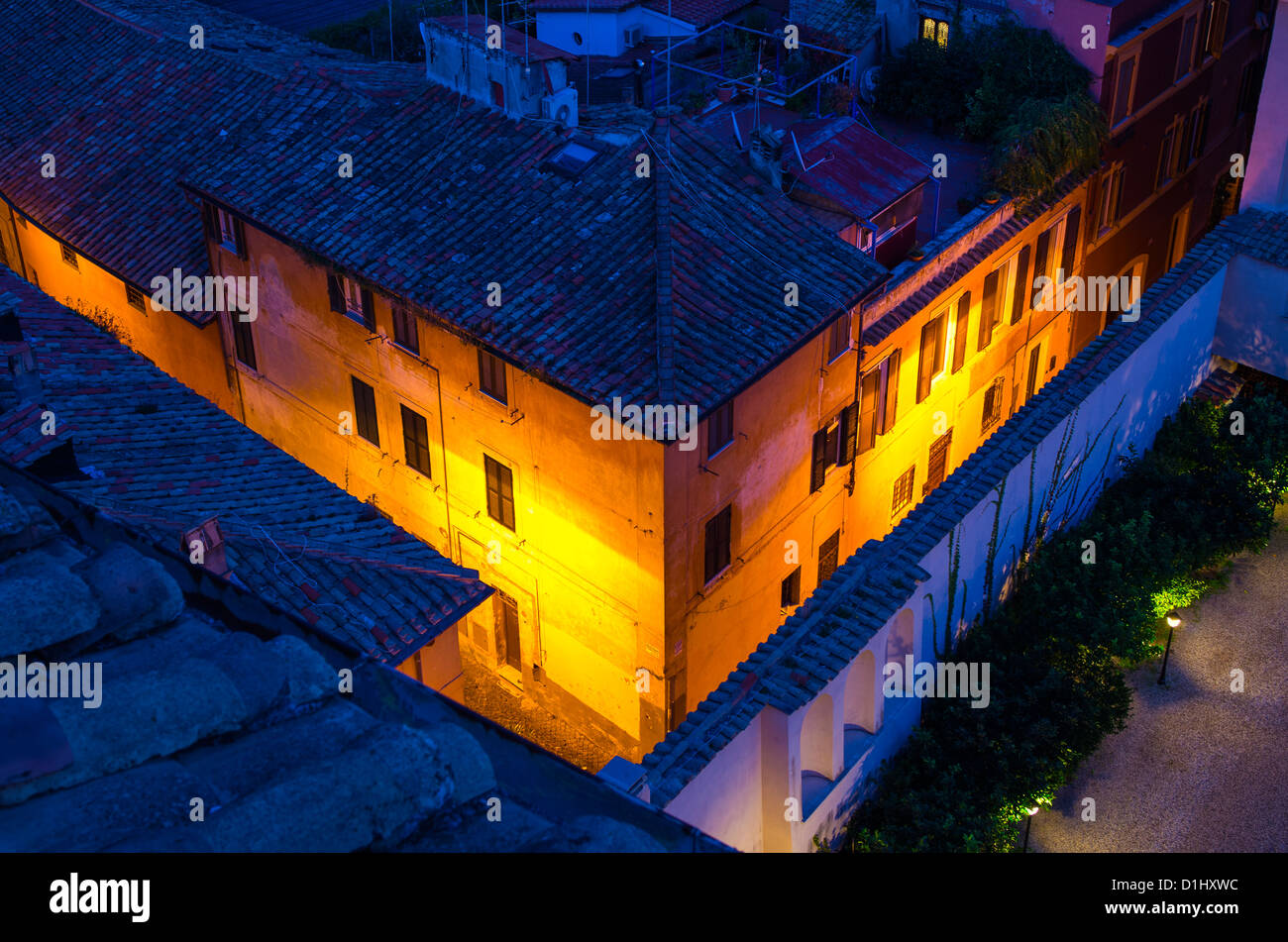 Twilight view of a house with warm red glow and blue skylight in Rome ...