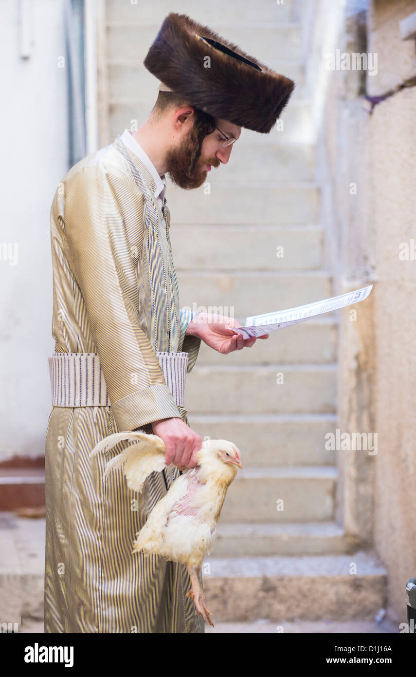 An ultra Orthodox Jewish man prays with a chicken during the Kaparot ...