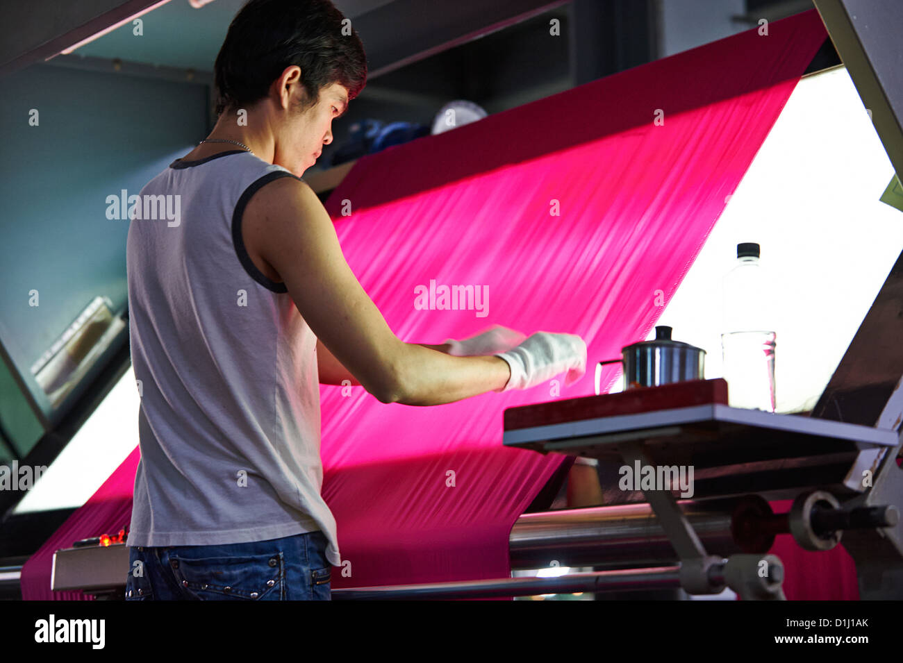 A worker inspects newly dyed fabric for inconstancies and holes Stock ...