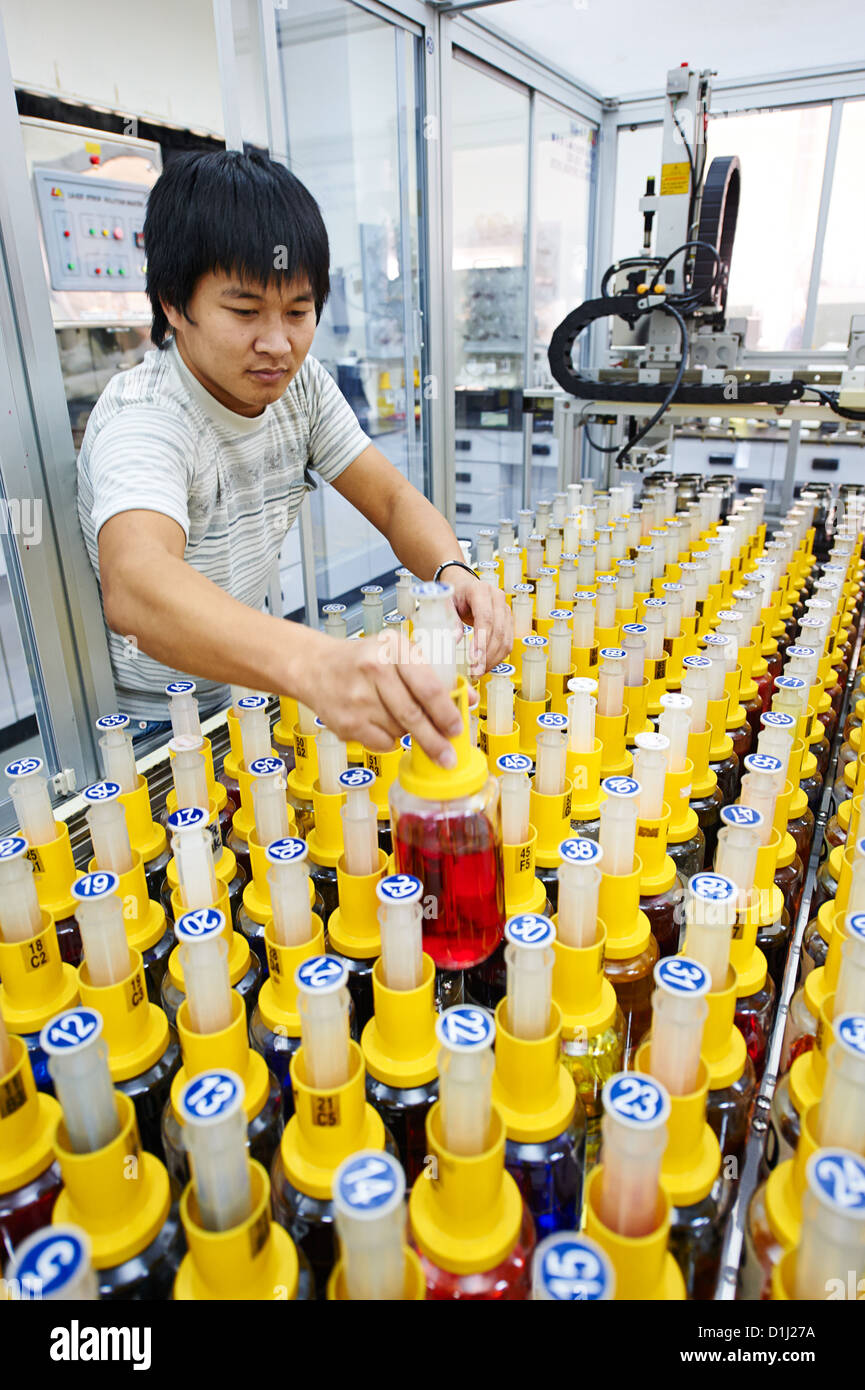 A worker adjusts a color dying machine at factory and research ...