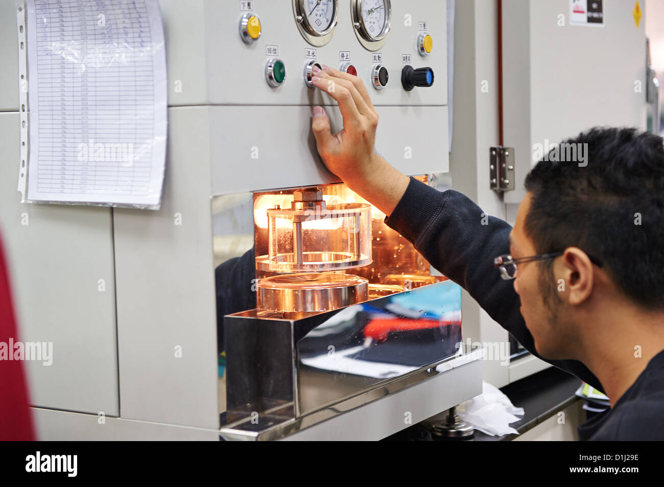 A worker testing fabric density at a machine Stock Photo - Alamy