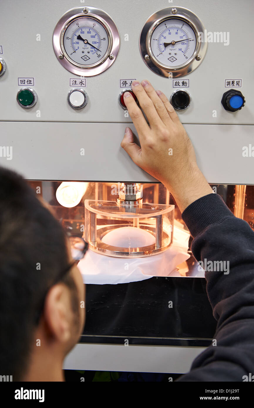 A worker testing fabric density at a machine Stock Photo - Alamy