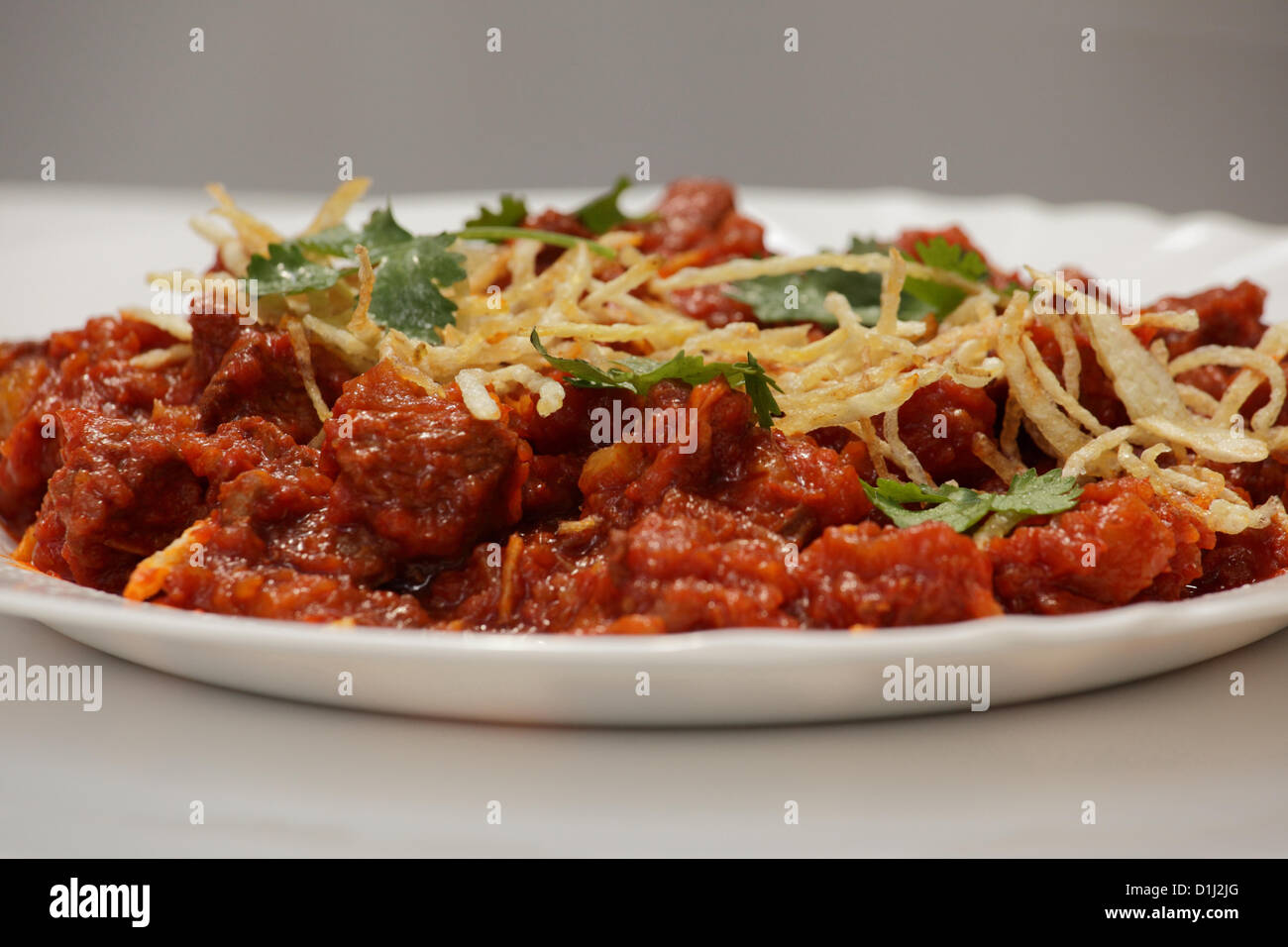 Non vegetarian Parsi dish Sallie boti Stock Photo - Alamy