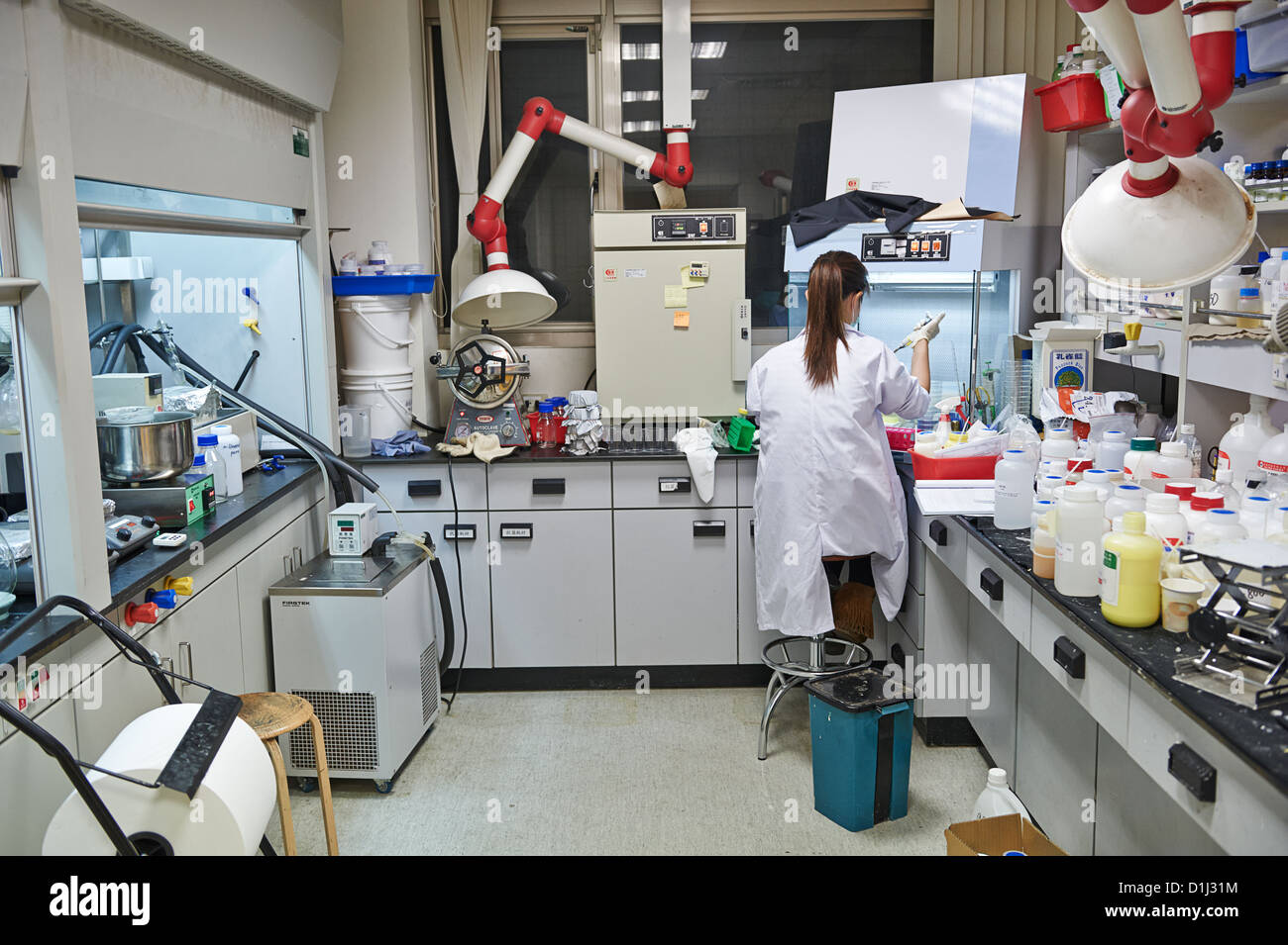 A lab worker filling test tubes at a textile research lab and factory ...