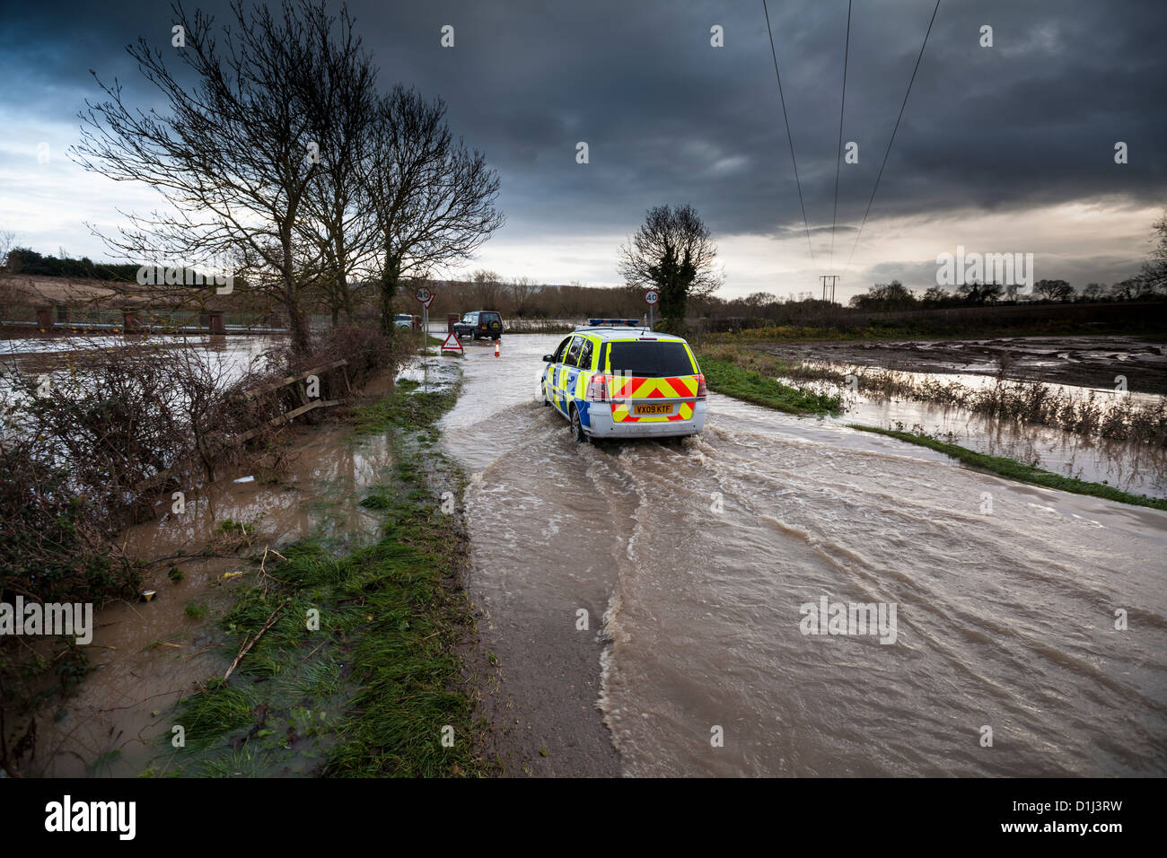 A police patrol vehicle moving through flood water in the winter ...