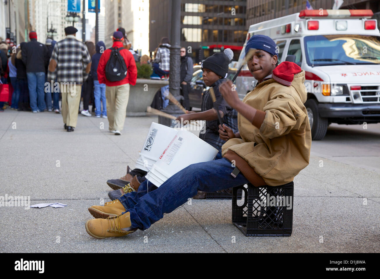 Two street performing young men using plastic buckets as drums ...