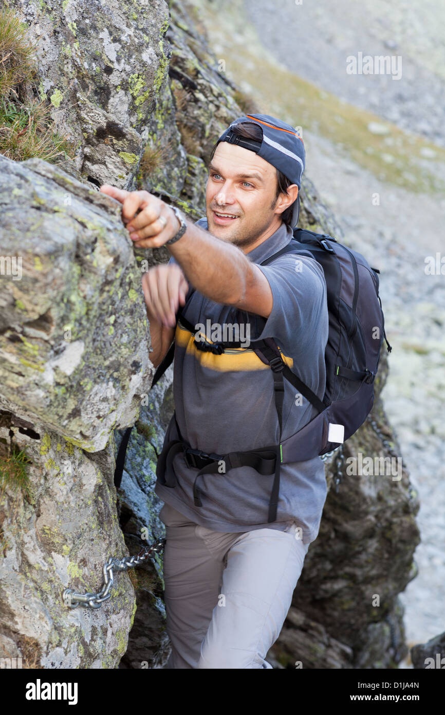 Young man hiking on difficult mountain trail Stock Photo - Alamy