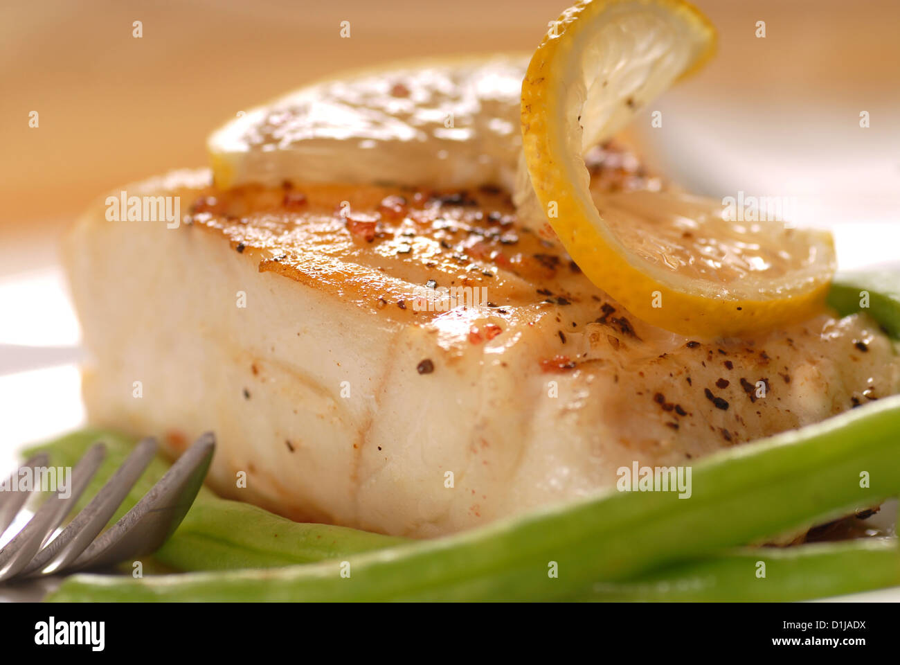 Fresh sautéed cod fillet with green beans and lemon Stock Photo - Alamy