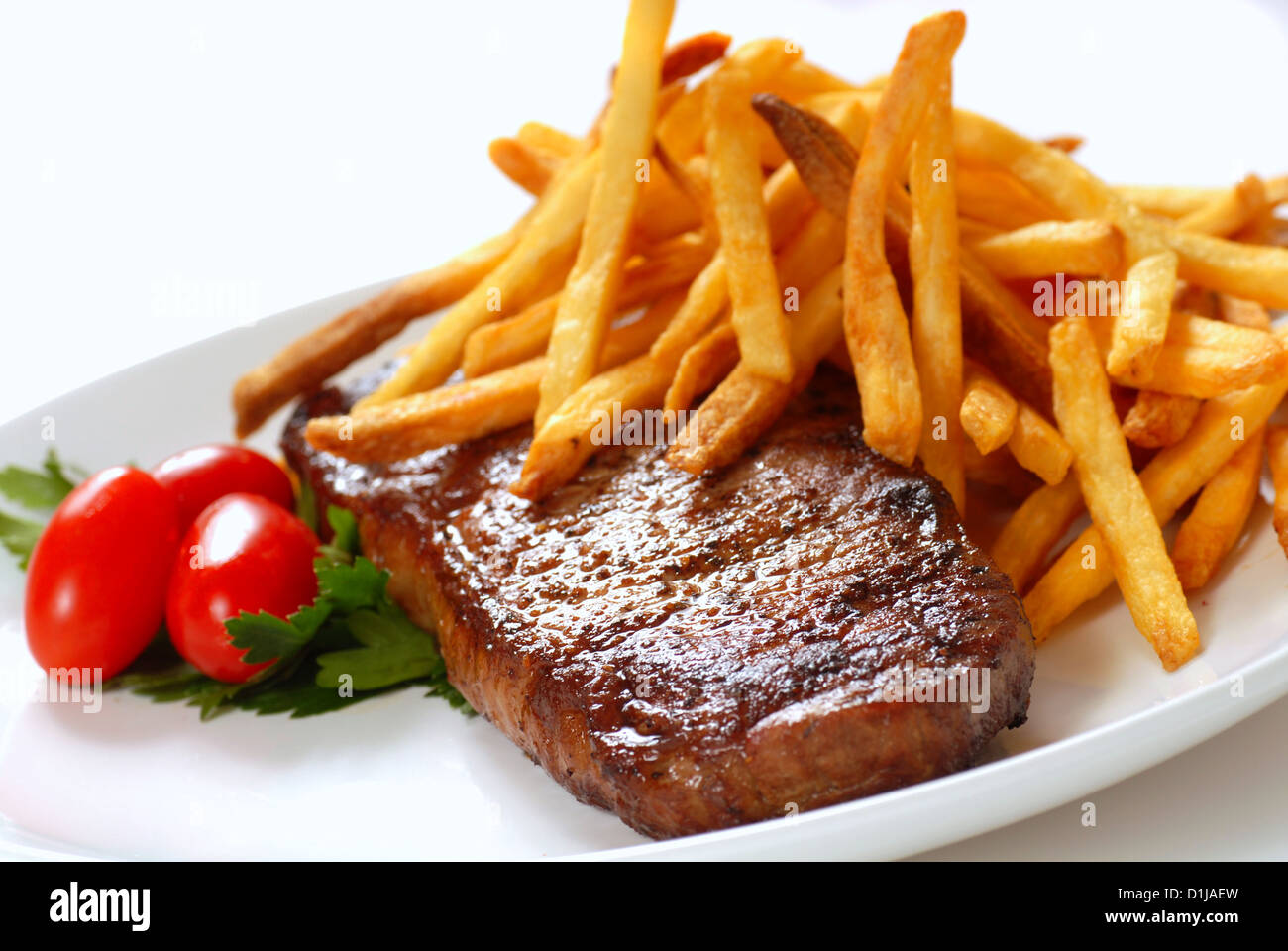 Freshly seared steak with French Fries and tomatoes Stock Photo - Alamy