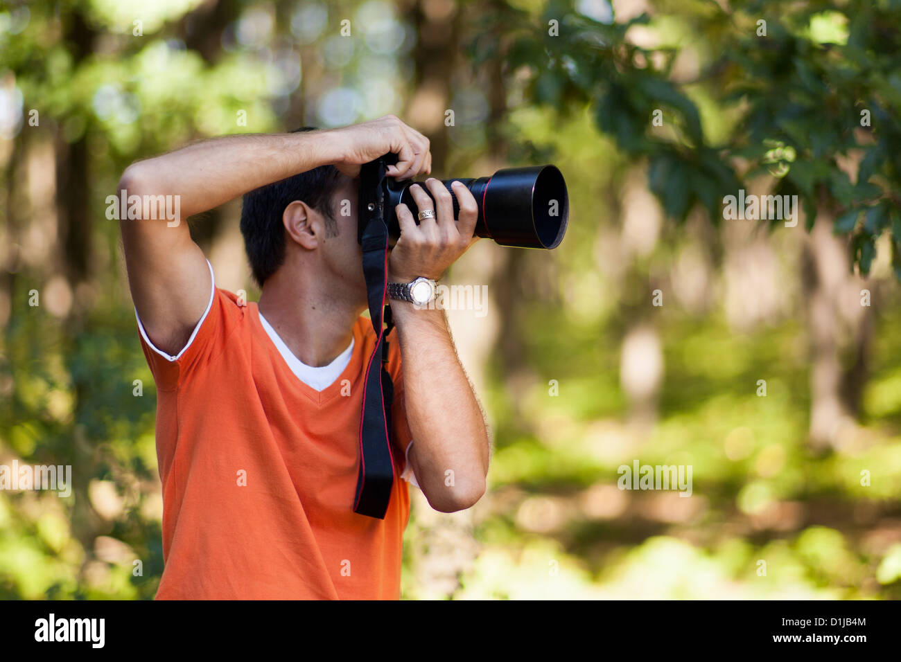 Young man taking pictures in the woods, closeup picture with blurred ...