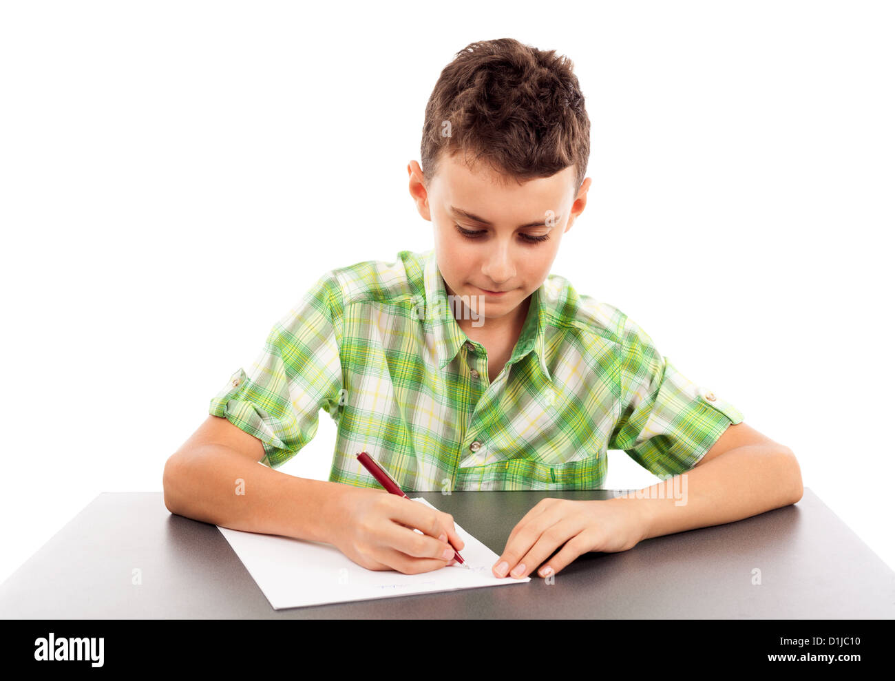 Schoolboy at exam writing at his desk, isolated on white background ...