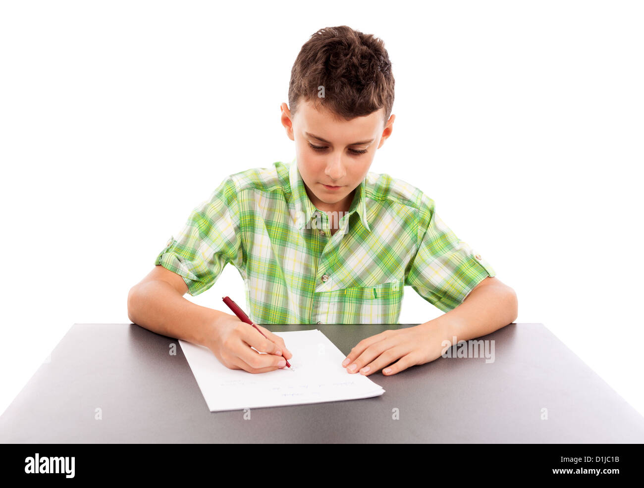 Schoolboy at exam writing at his desk, isolated on white background ...