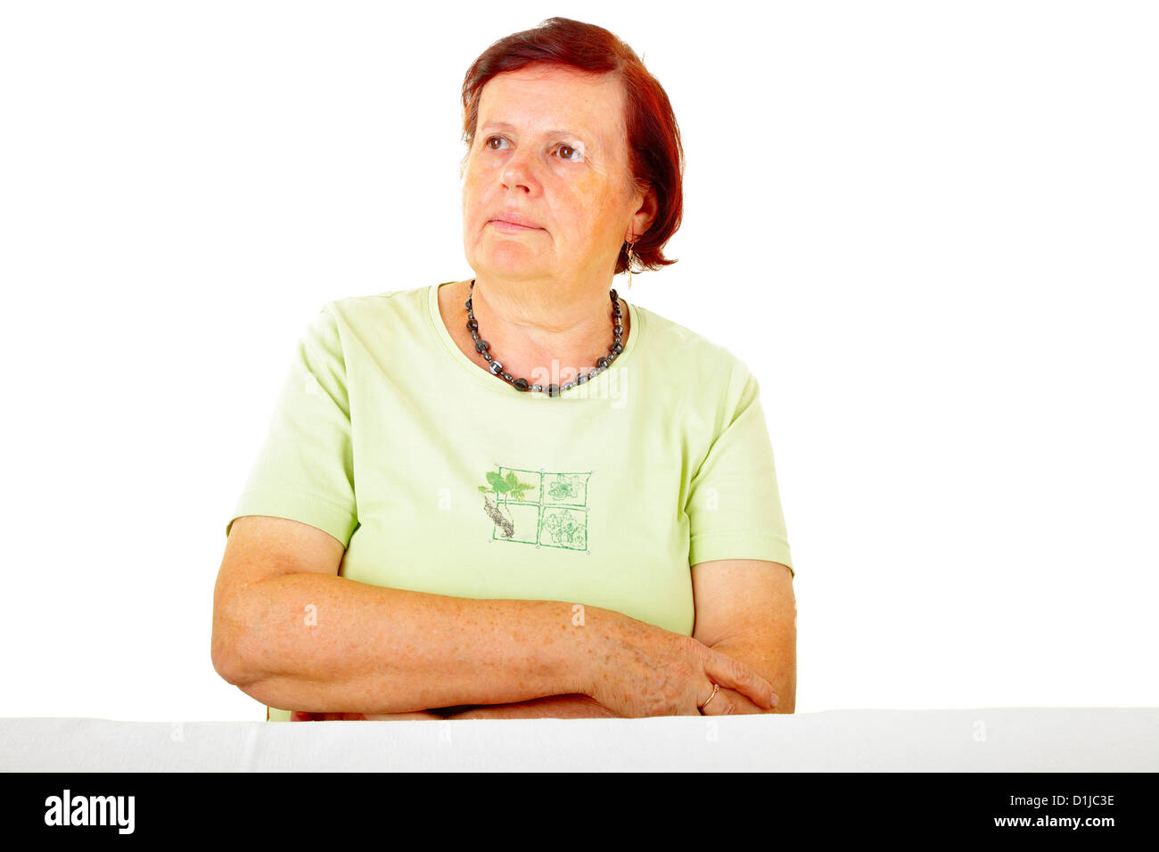 pensive senior woman sitting on a table Stock Photo - Alamy