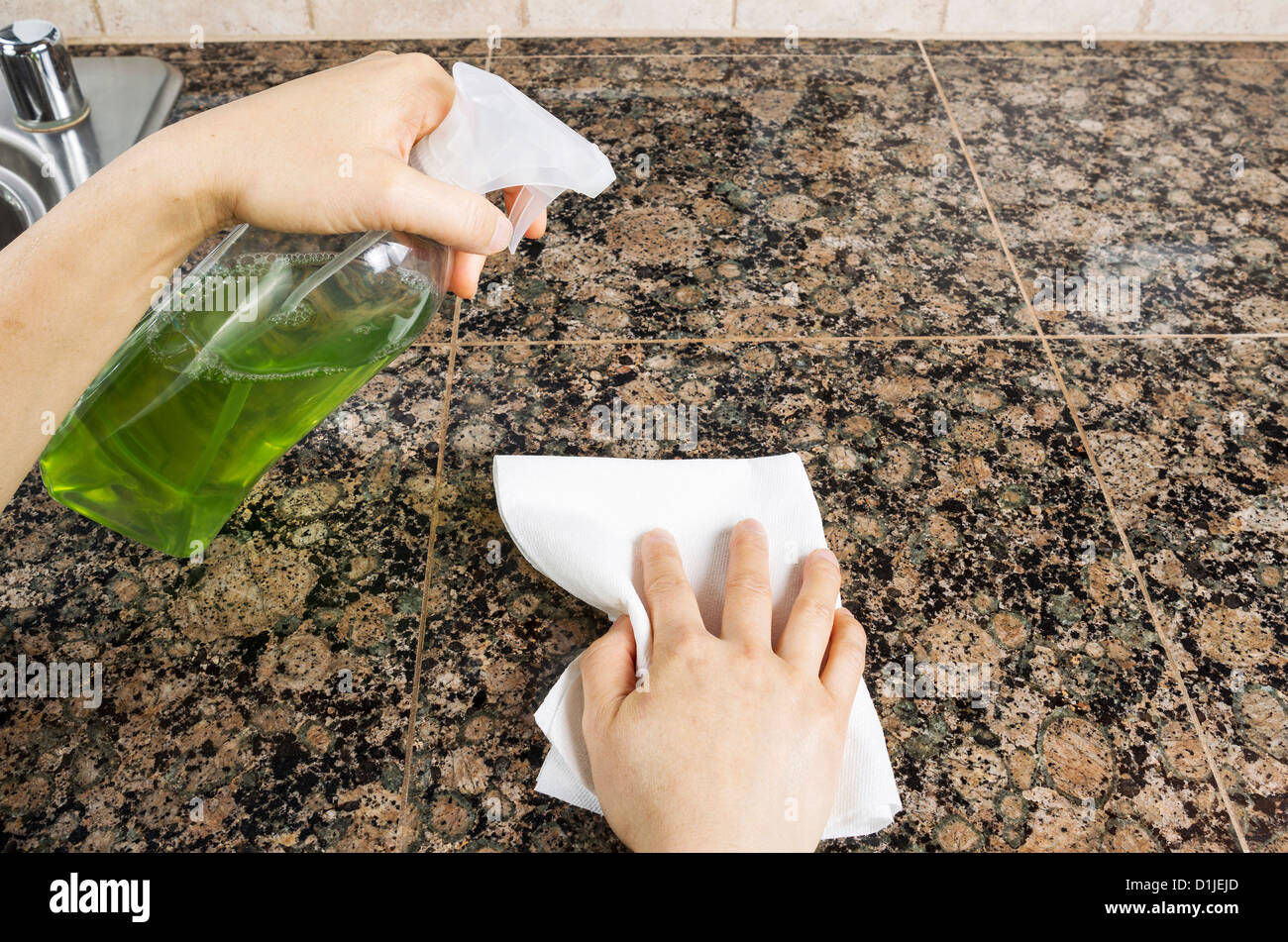 Hand holding spray bottle to clean stone kitchen counter tops Stock ...