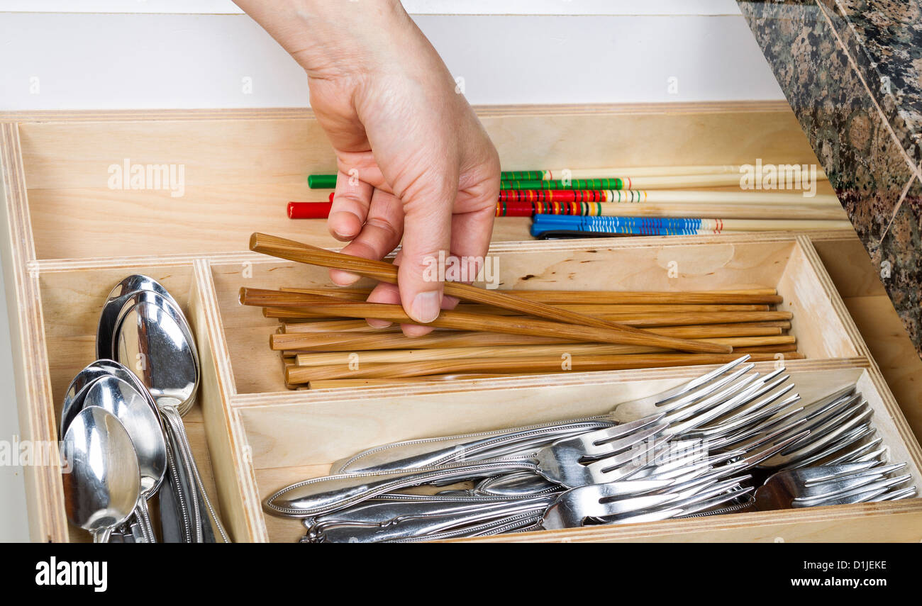 Female hand picking up wooden chop sticks out of kitchen drawer Stock ...