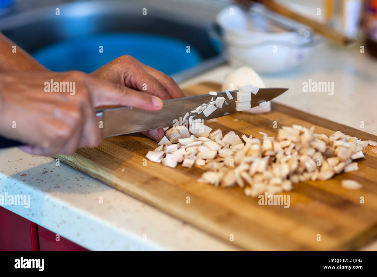 Closeup of a woman's hands chopping mushrooms on a wooden board Stock ...