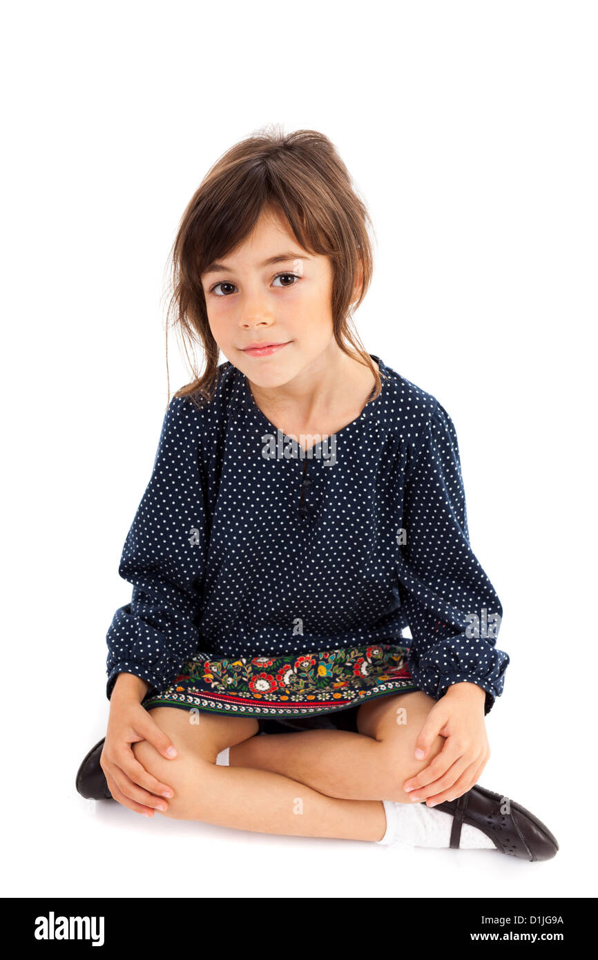Full length portrait of a little girl sitting with crossed legs ...