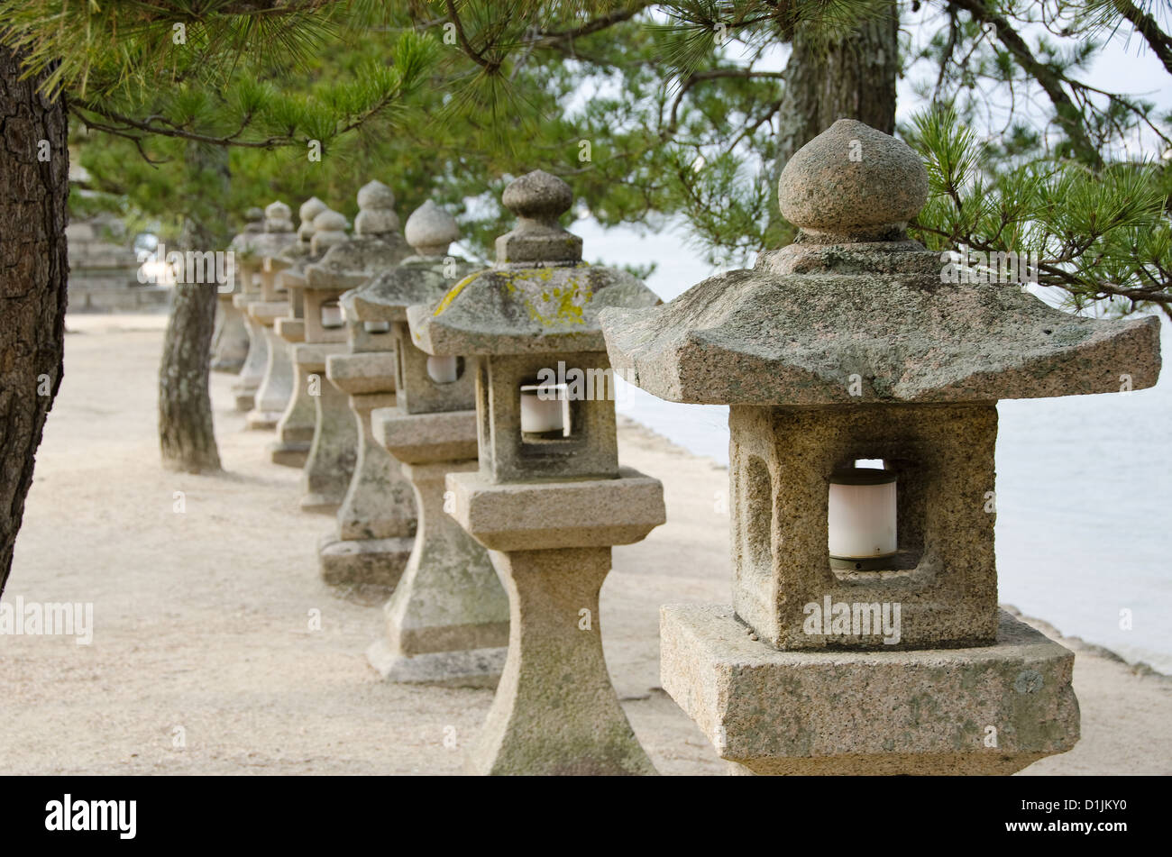 Row of stone lanterns in Japan at the Itsukushima Shrine Stock Photo ...