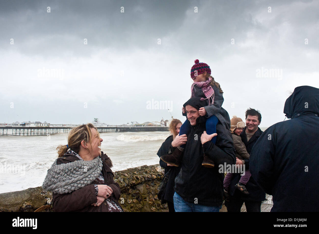 A family enjoy the brisk weather on the beach. Specatators and swimmers ...