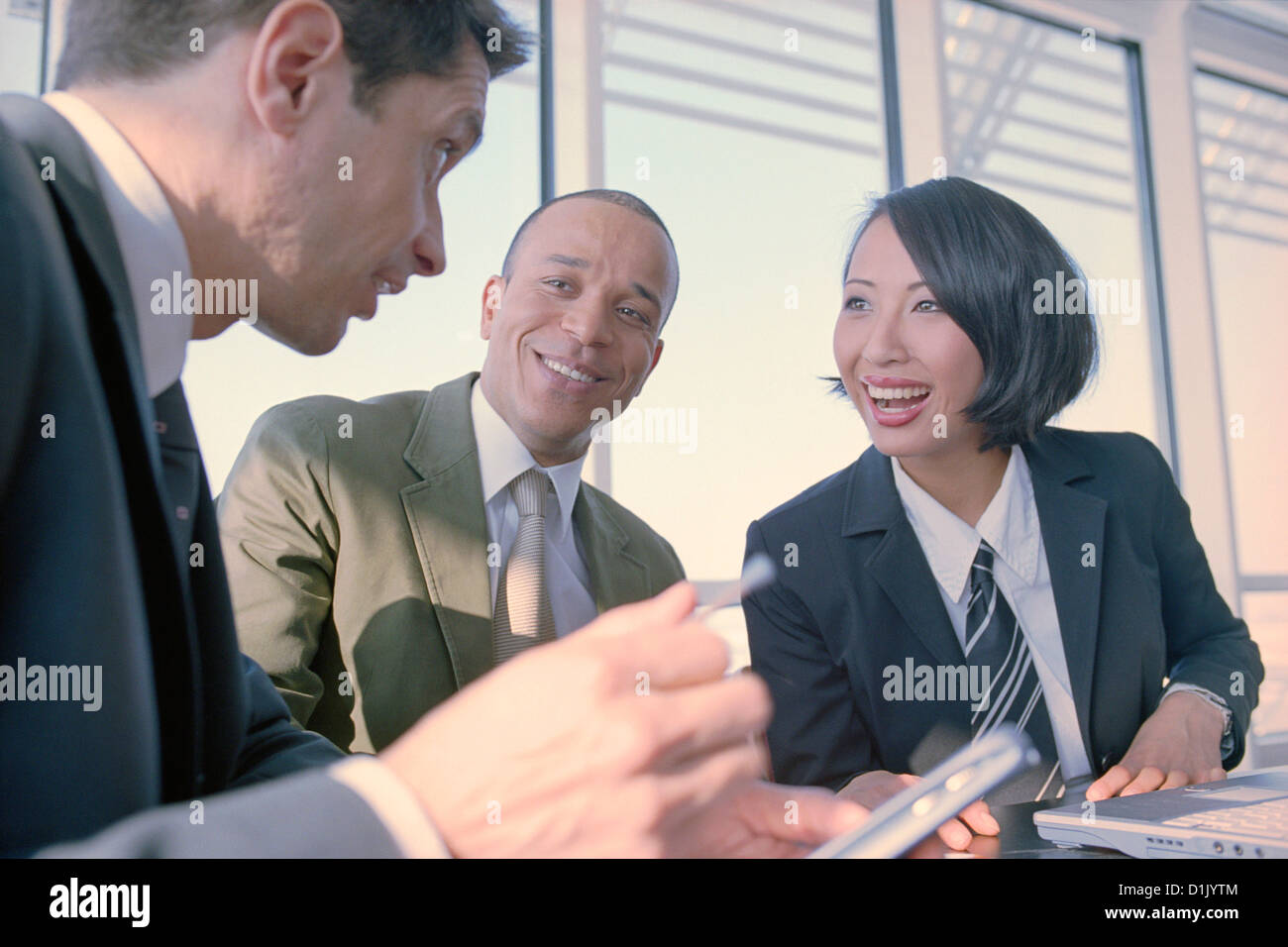 Smiling business people meeting at table in conference room License ...