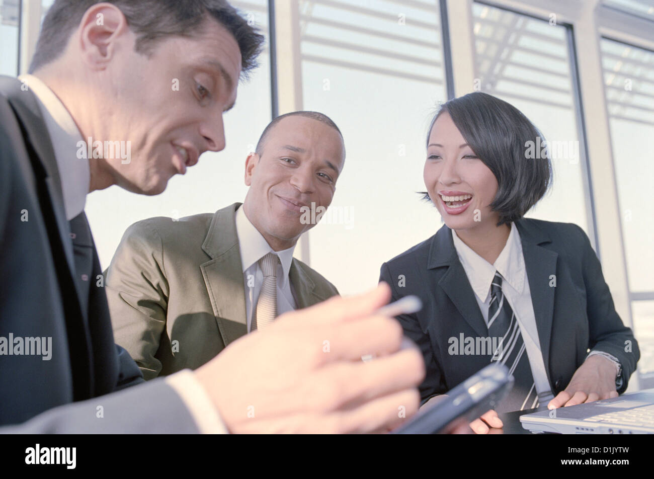 Smiling business people meeting at table in conference room License ...