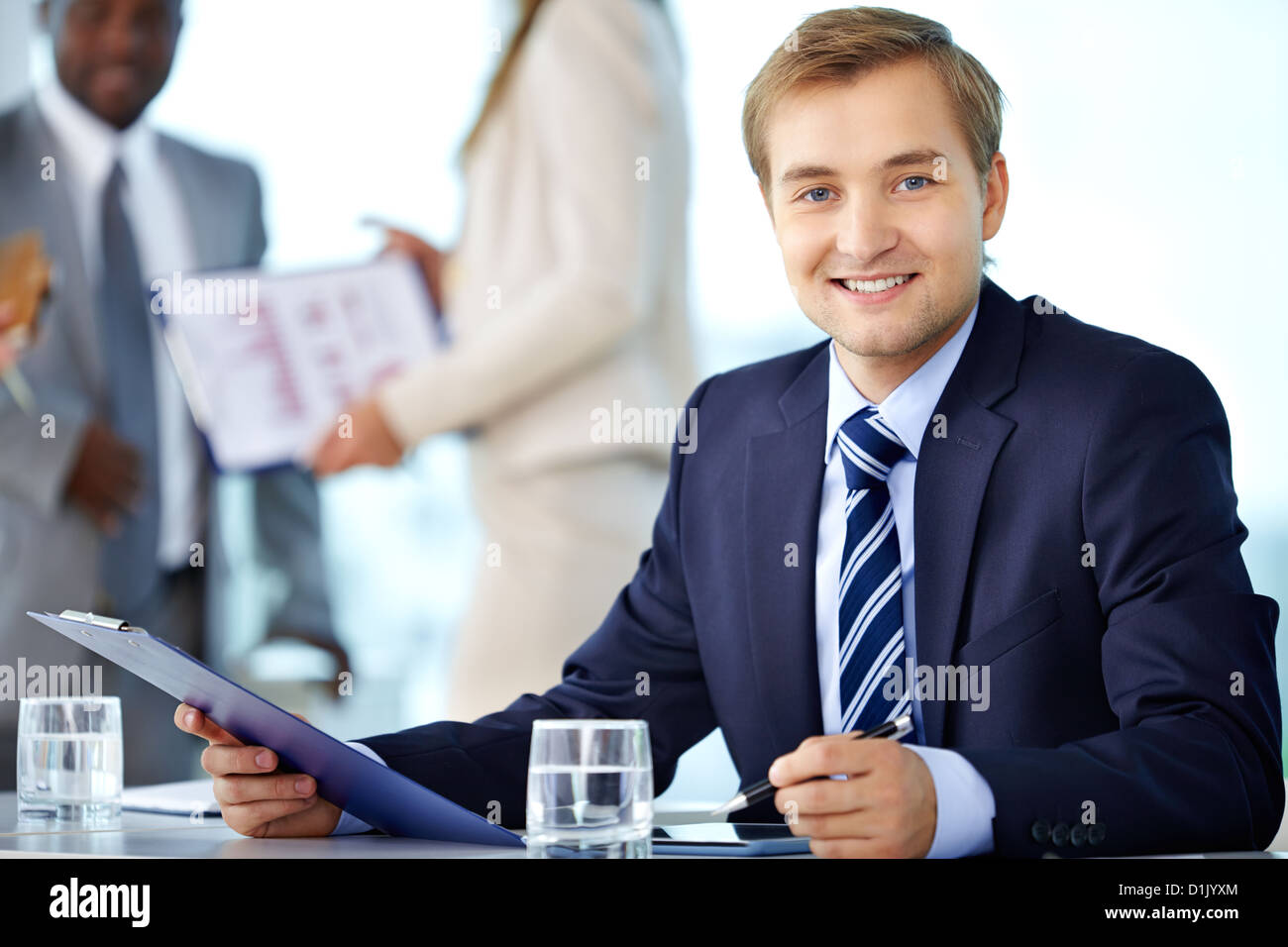 Portrait of confident boss looking at camera with his partners ...