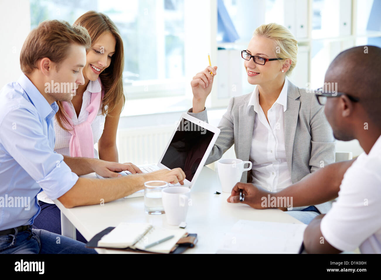 Group of friendly businesspeople having meeting Stock Photo - Alamy