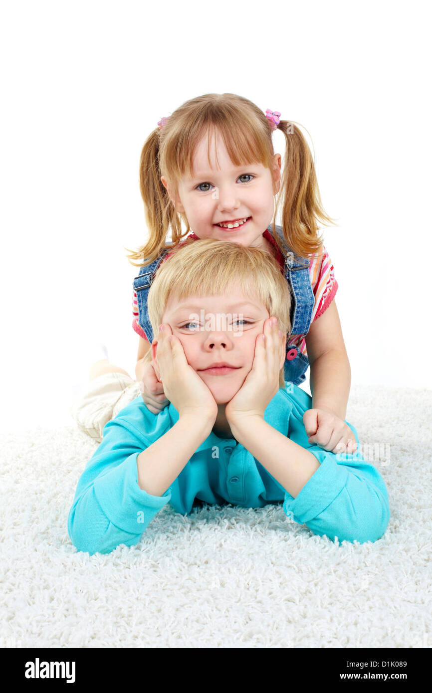 Two kids lying on the floor and looking at camera Stock Photo - Alamy